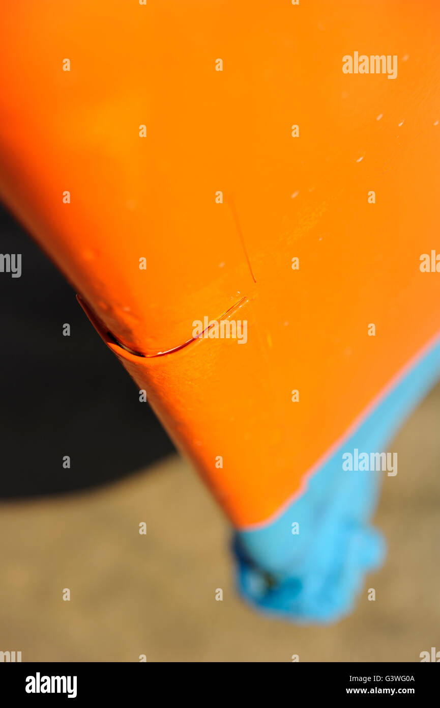 Hull of bright orange fishing boat with blue stripe Stock Photo - Alamy