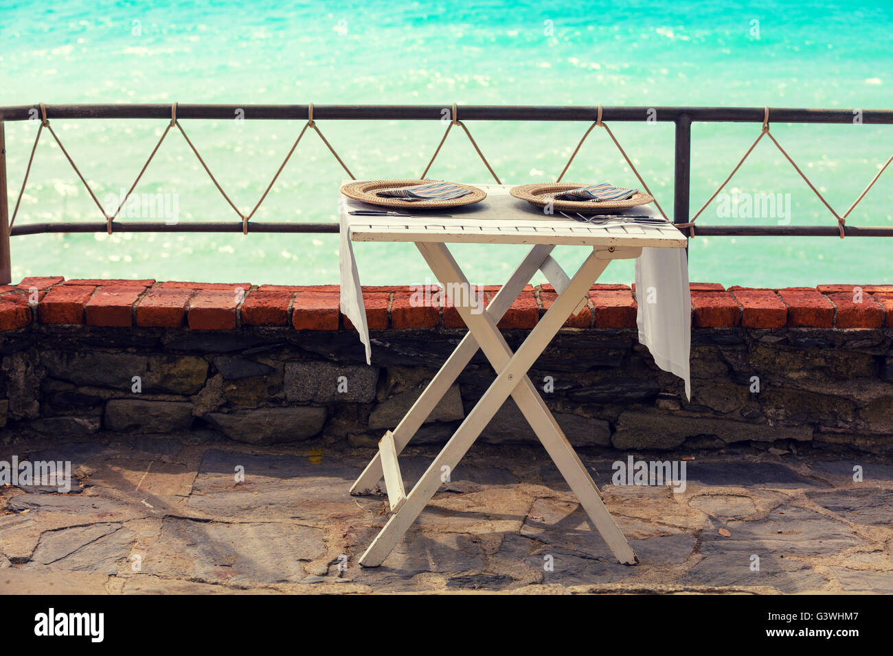Served table for two with two plates for dinner at the beach on terrace ...