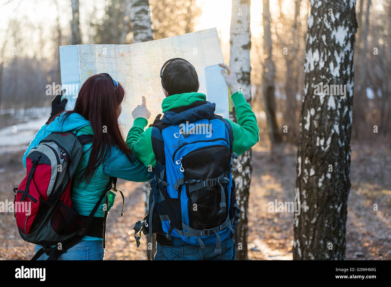 Young couple hikers looking at map Stock Photo - Alamy