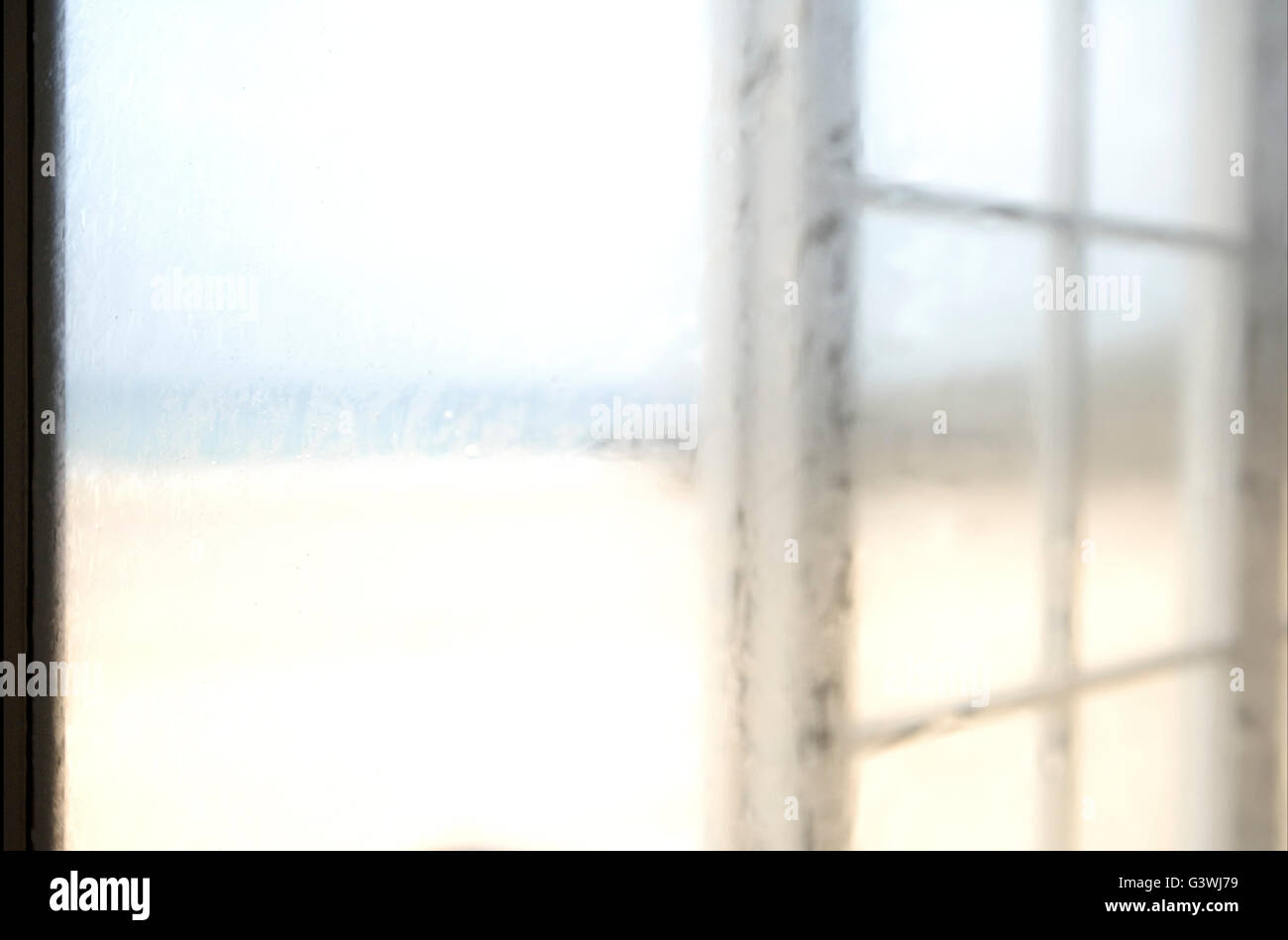 Blurred abstract shot of open window with out of focus beach and sand ...