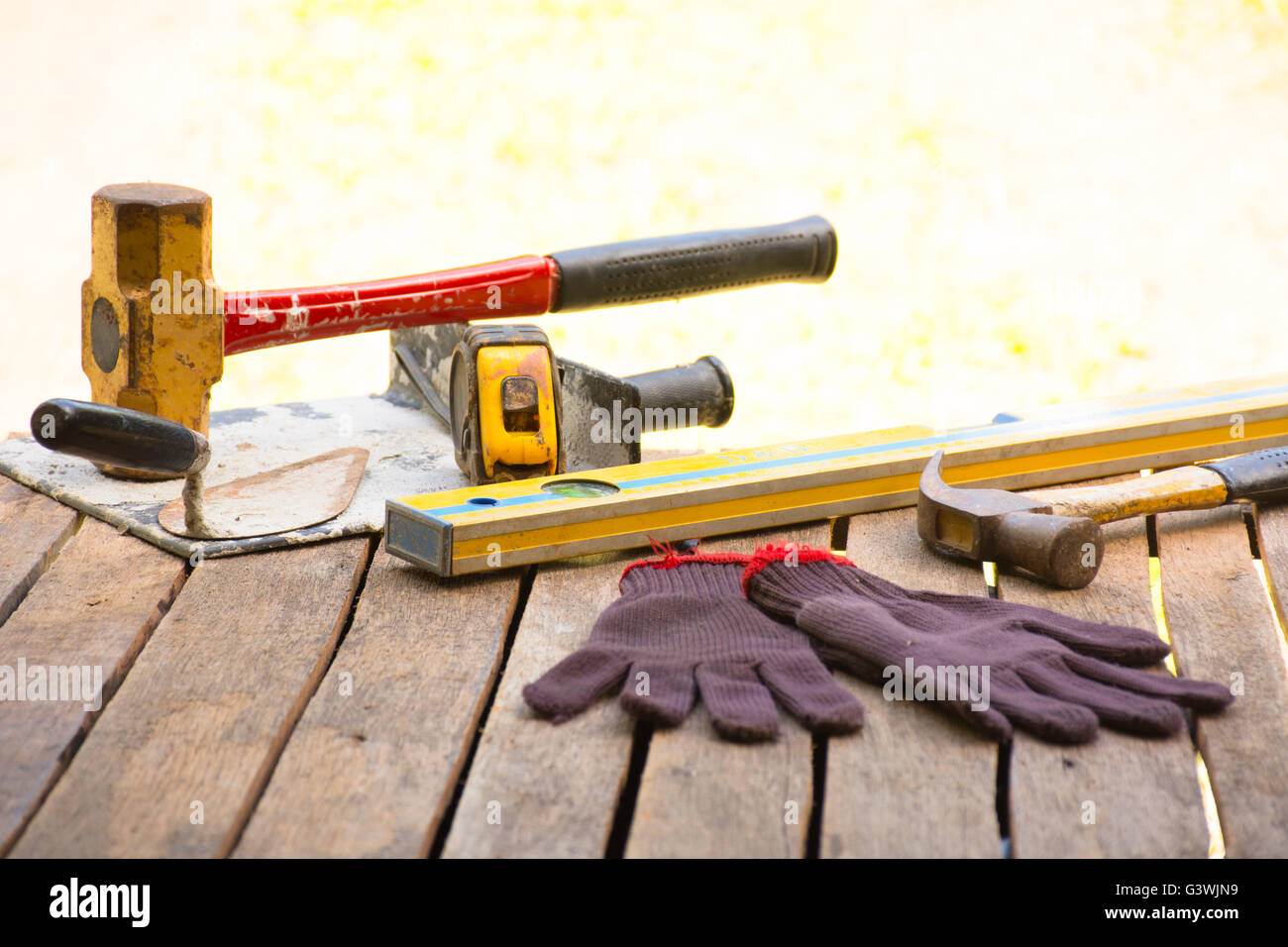 Masonry tool background such as glove and tape measure and sledgehammer ...