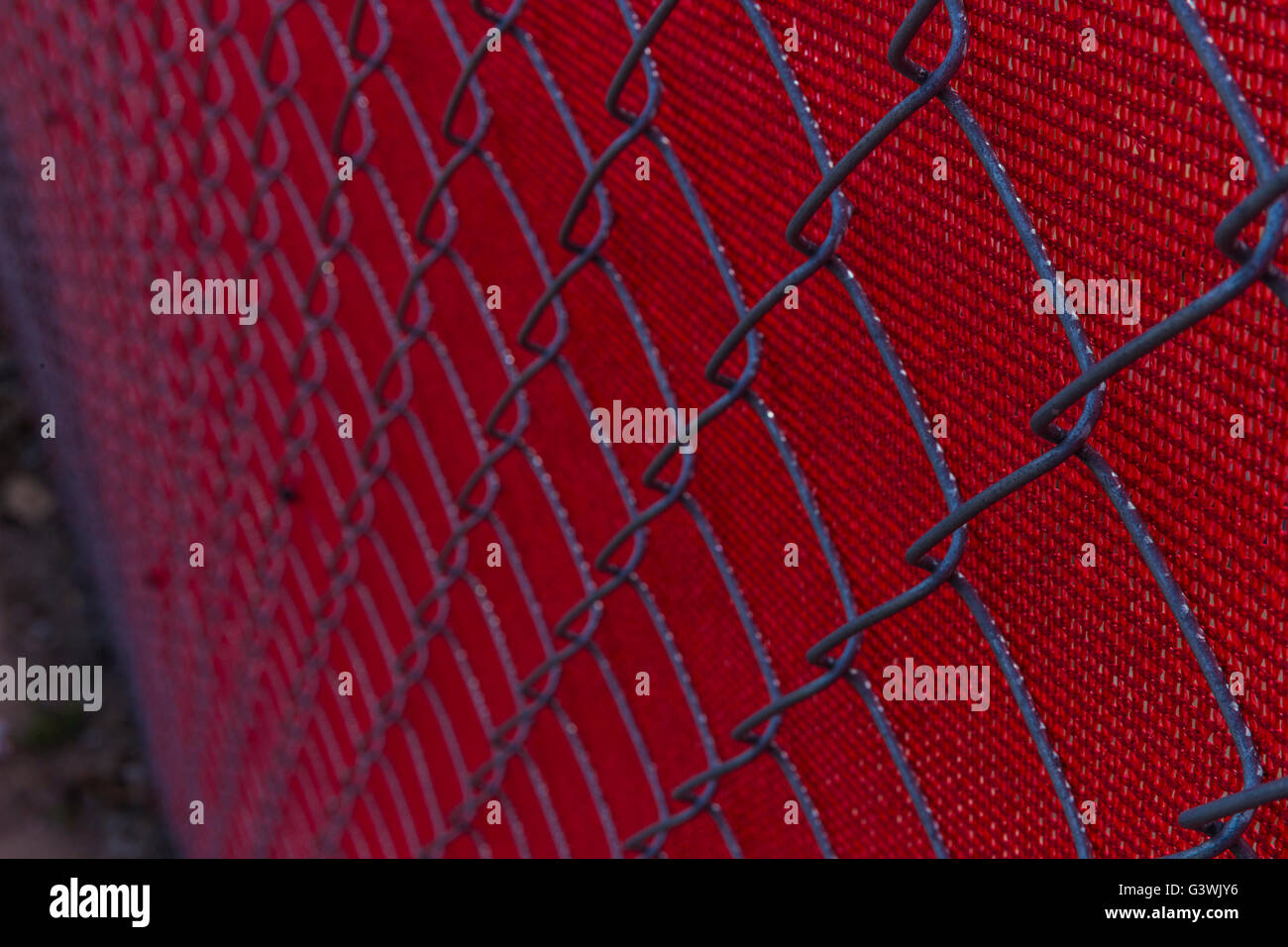 Chain link fence with red windblocking fabric Stock Photo - Alamy