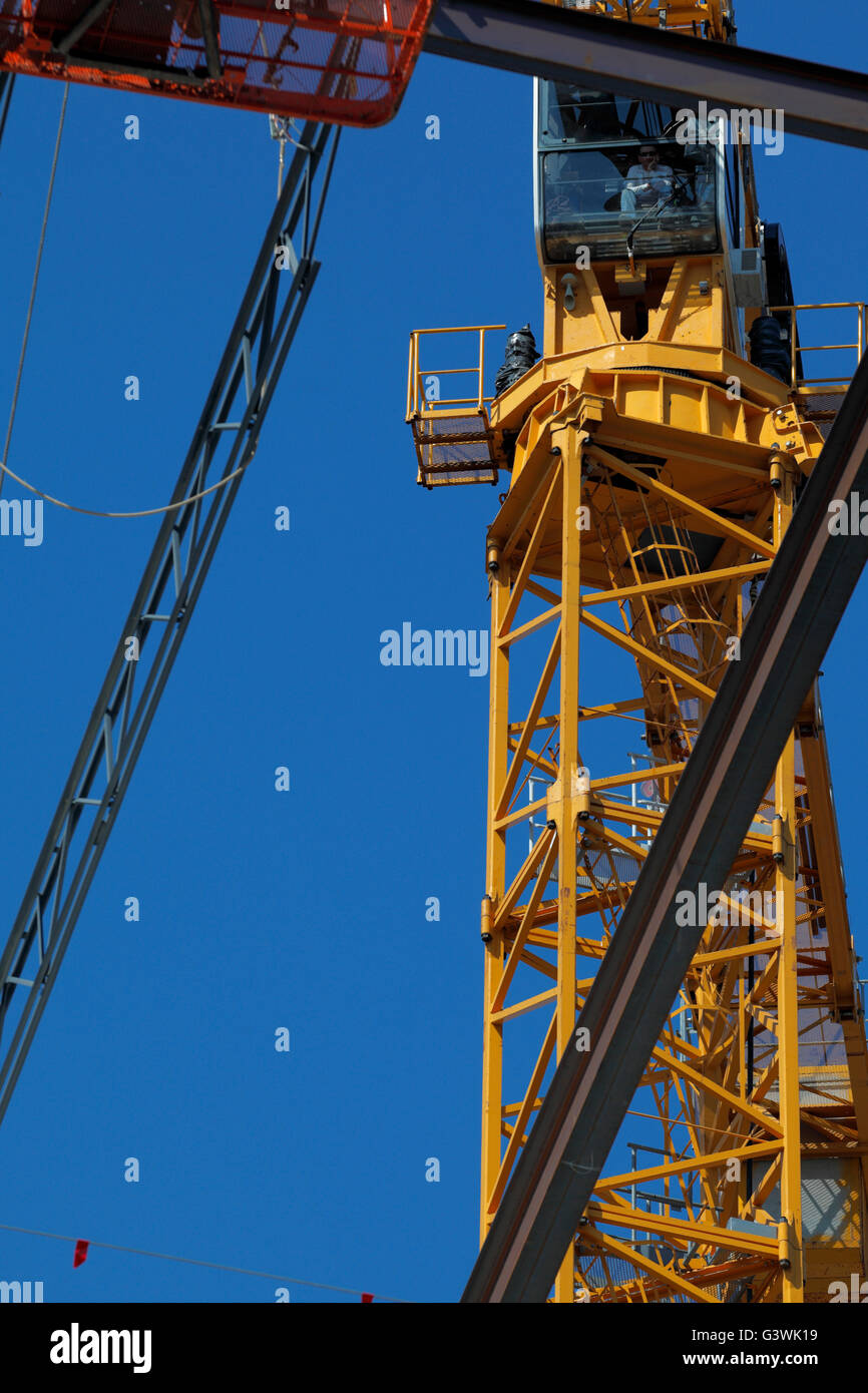 Crane operator in cab watching construction site from tower crane Stock ...