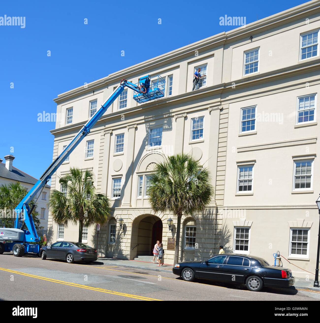 Man on Top Ledge of Building Stock Photo - Alamy