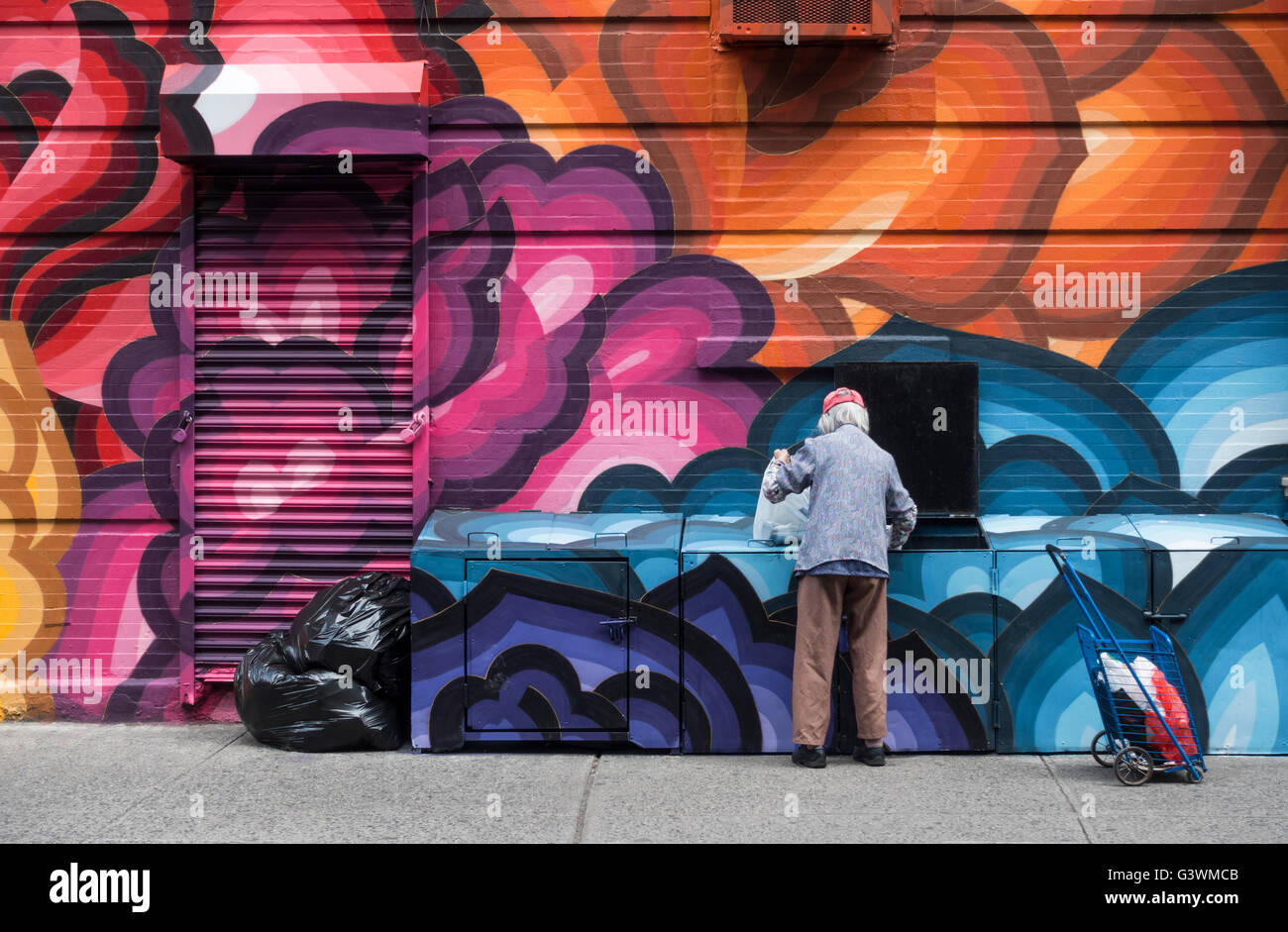 Elderly Asian woman gathering cans and plastic bottles from trash bins ...