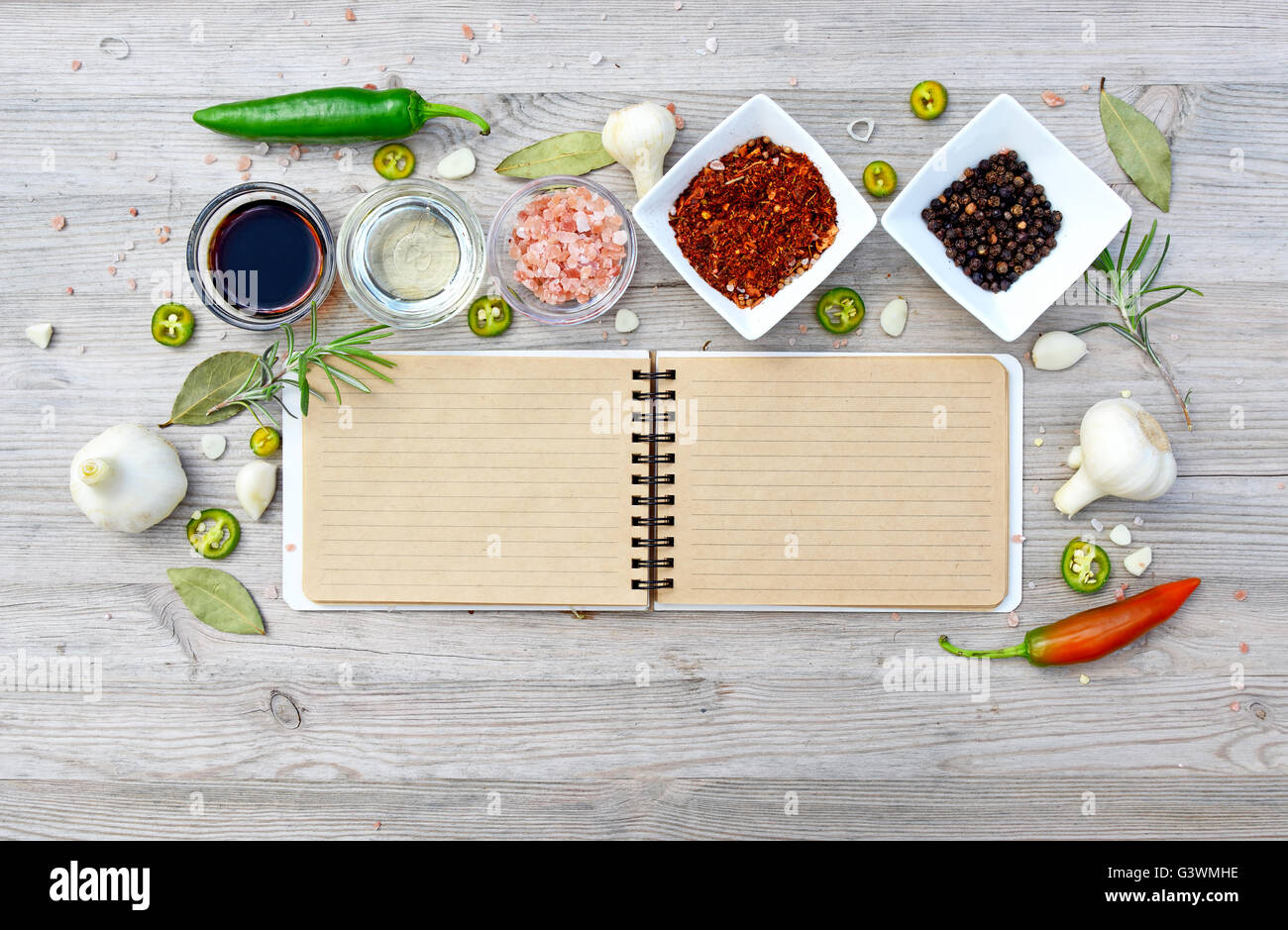 Blank open notebook for notes and pepper, bay leaf, rosemary, onions ...