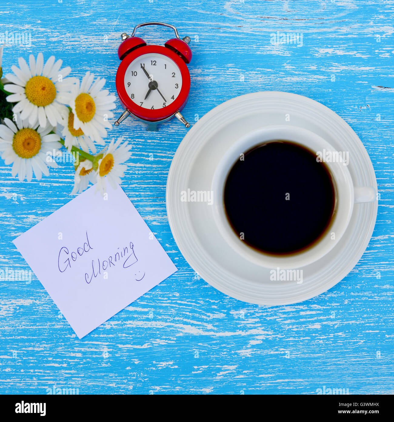 Daisy flowers and cup of tea with good morning note on rustic blue ...