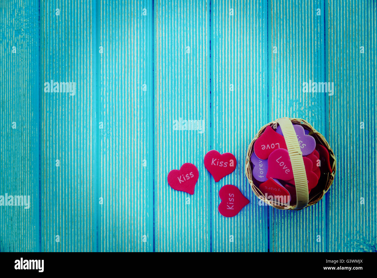 Full basket with hearts on a blue wooden background. Photo in vintage ...