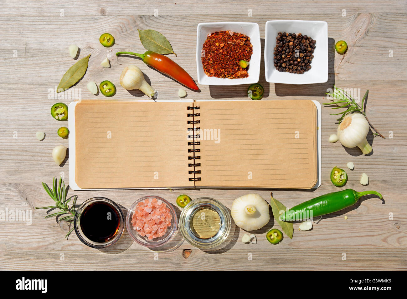 Blank open notebook for notes and pepper, bay leaf, rosemary, onions ...