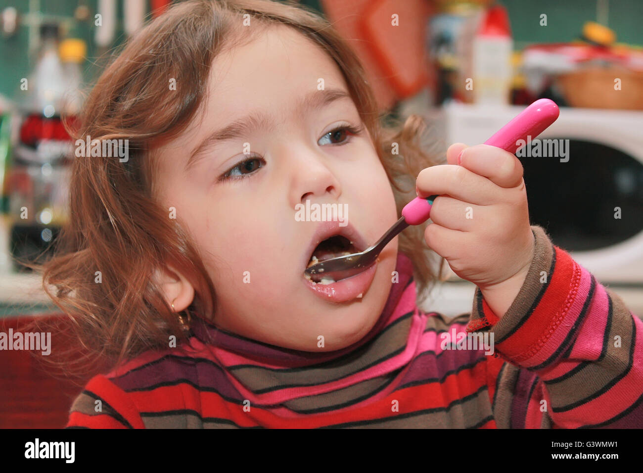 Girl eat with spoon Stock Photo - Alamy