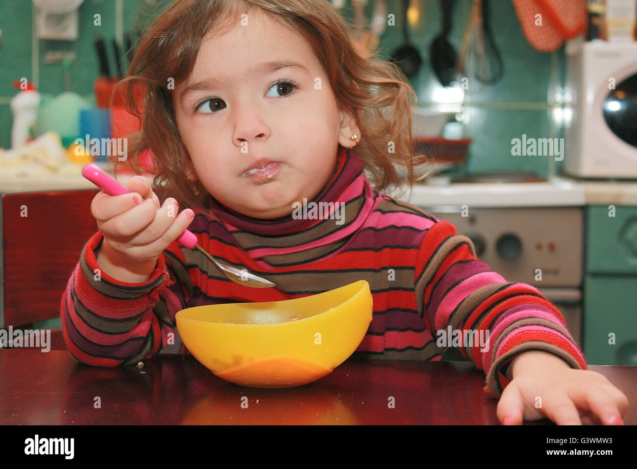Girl eat with spoon Stock Photo - Alamy
