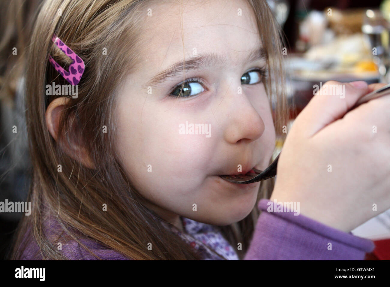 Girl eating with fork Stock Photo - Alamy