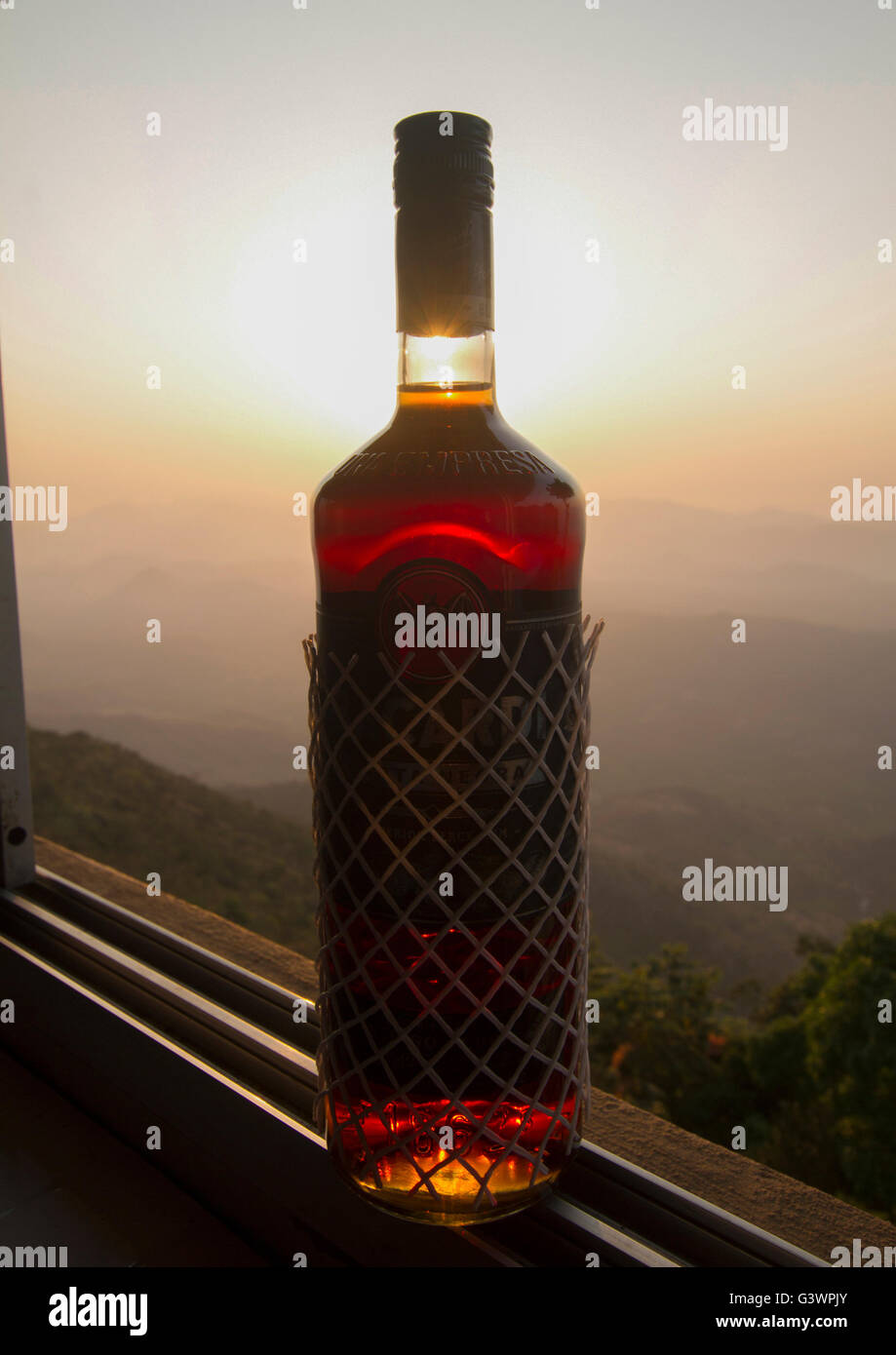Evening sun rays passing through a full bottle of rum Stock Photo - Alamy