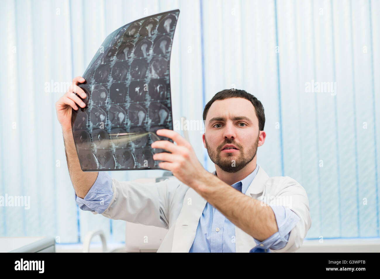Young doctor holding x-ray mri scan and looking worried Stock Photo - Alamy