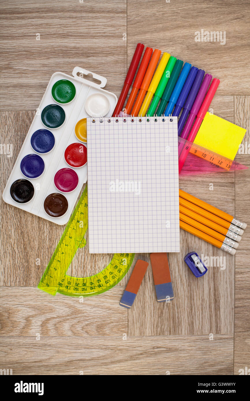 Wooden desk, covered with multiple office supplies. Back to school ...