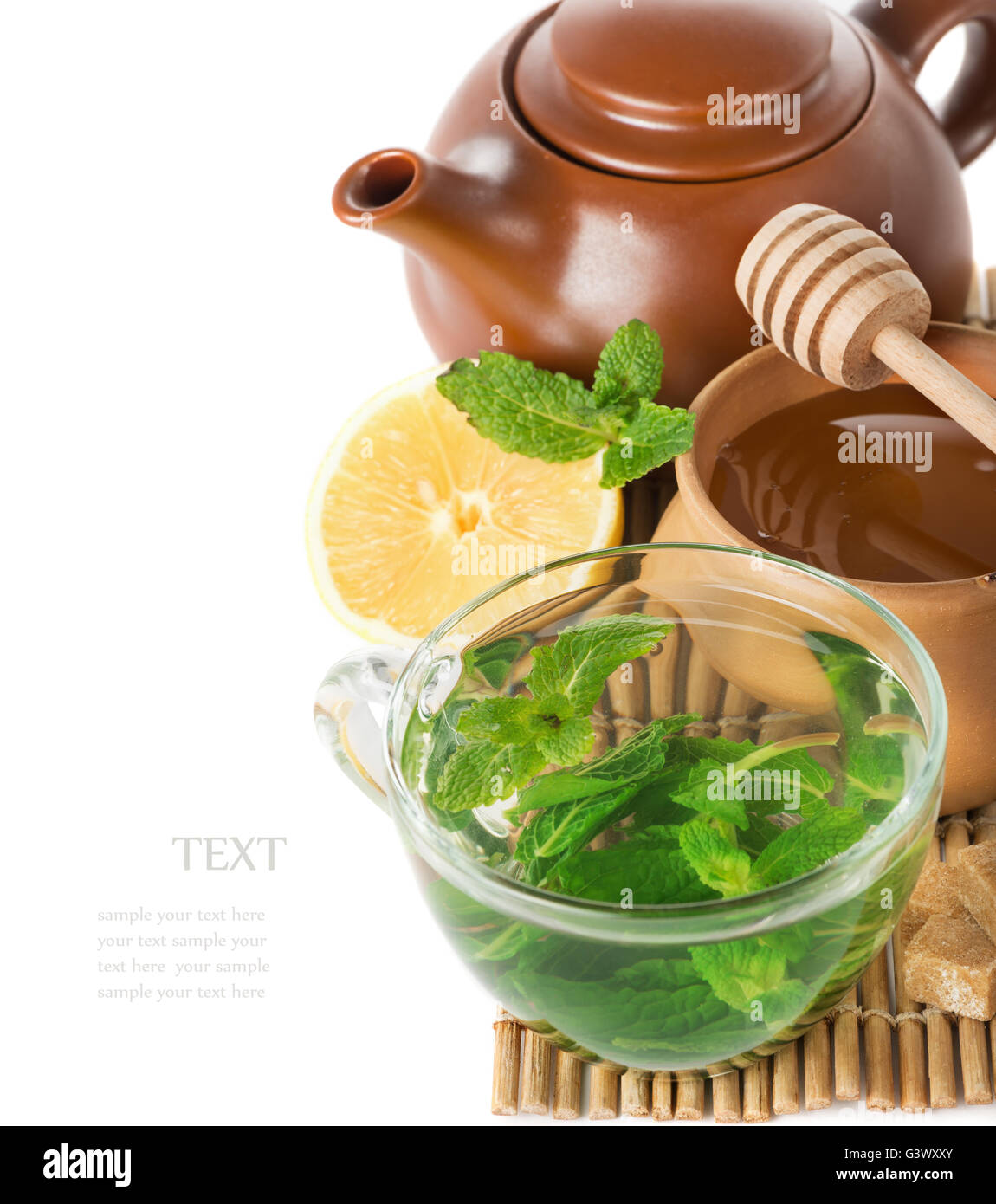 mint tea in a transparent glass cup, teapot, lemon, honey and honey ...