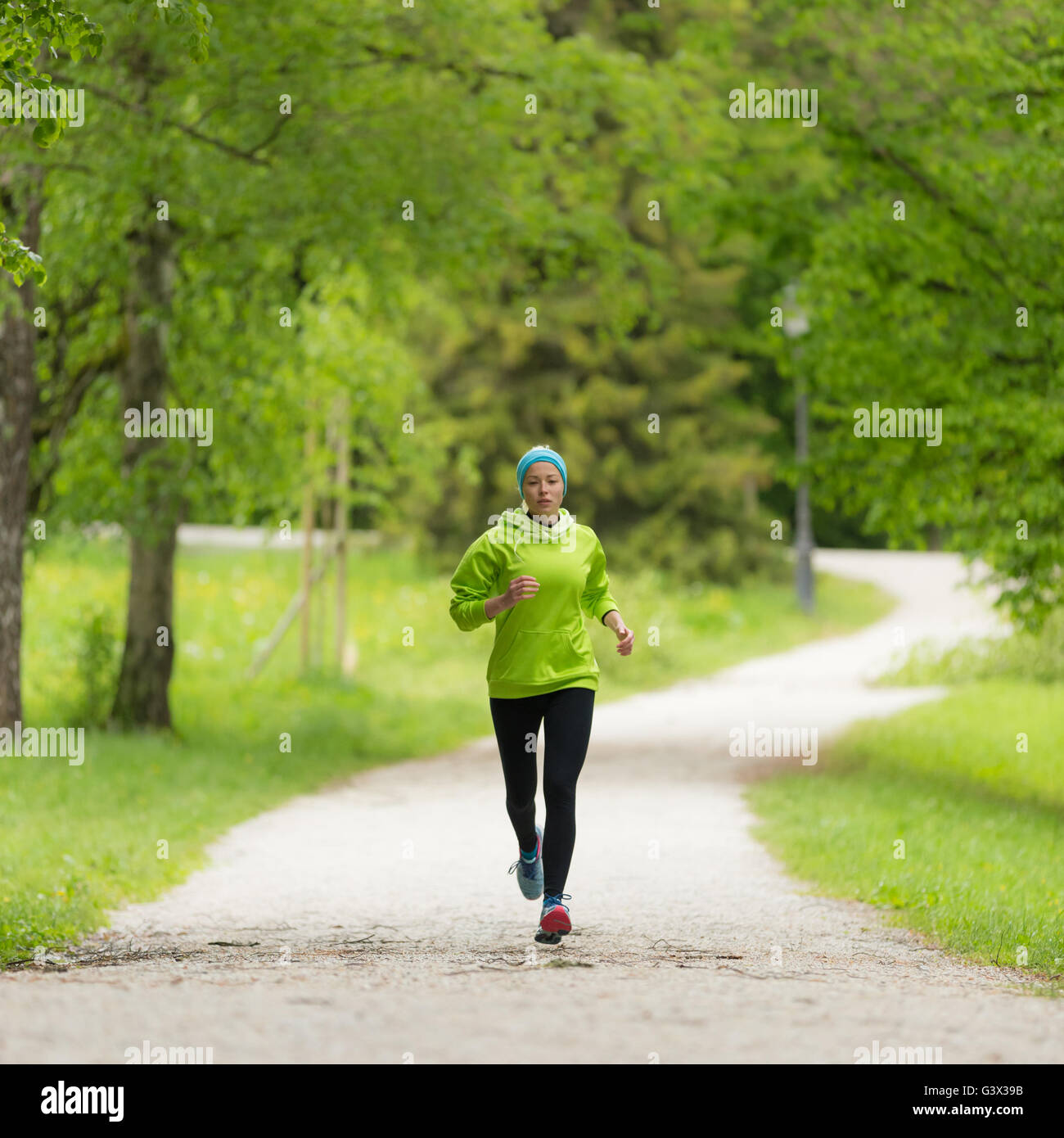 Sporty young female runner in city park Stock Photo - Alamy