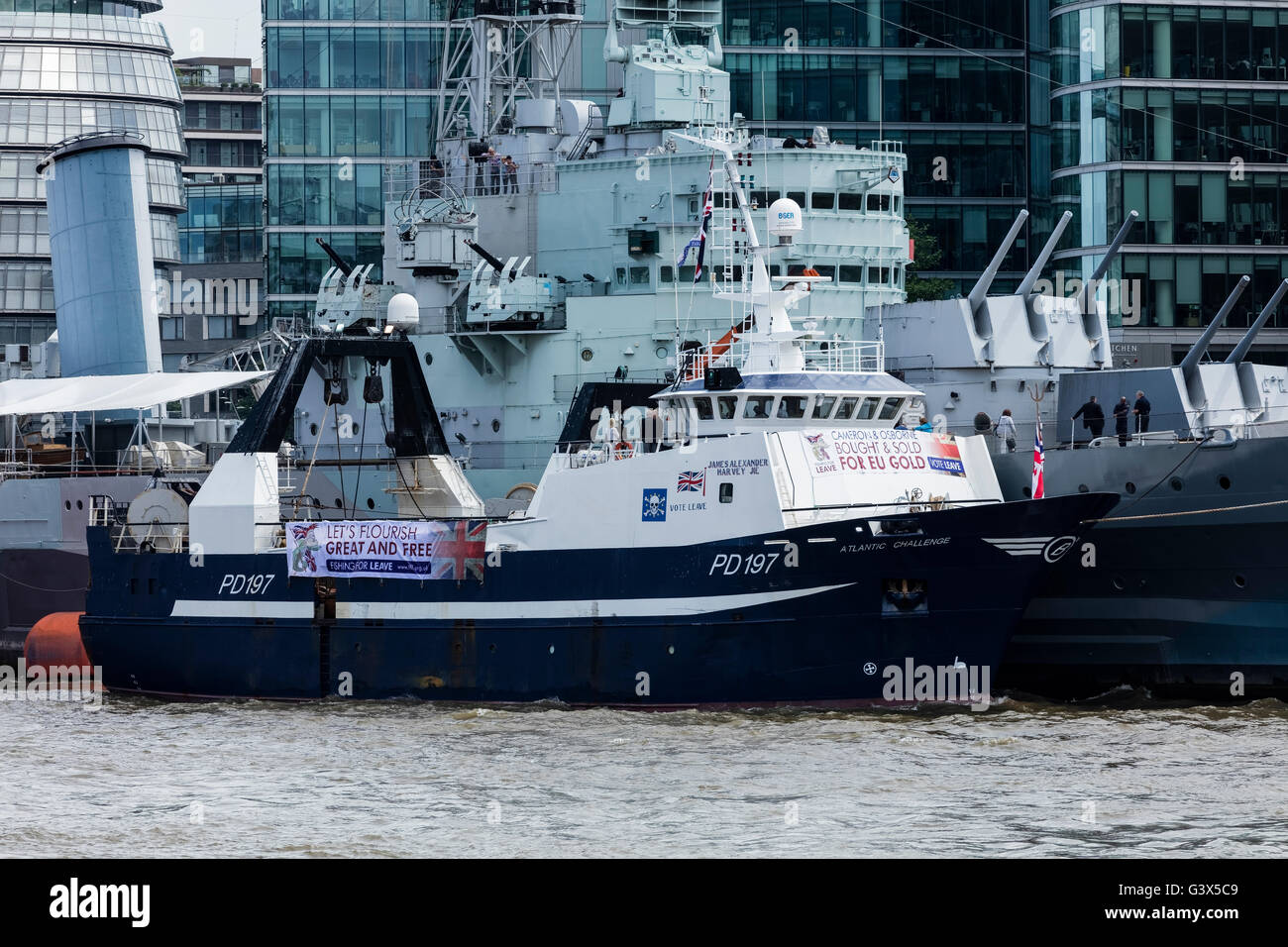 Fishing trawler on the River Thames in front of HMS Belfast in the Pool ...