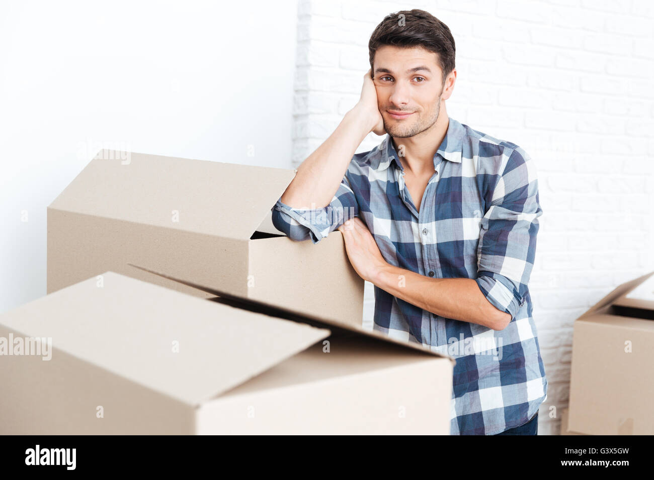 Happy handsome young man moving in and carrying carton boxes Stock ...