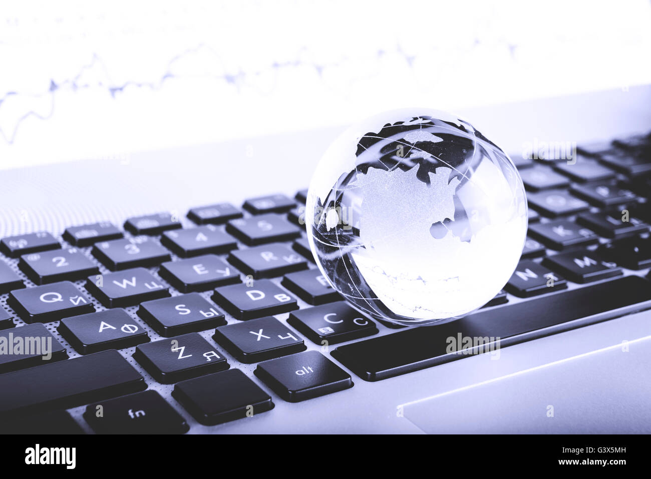 business concept of a glass globe on a laptop keyboard Stock Photo - Alamy