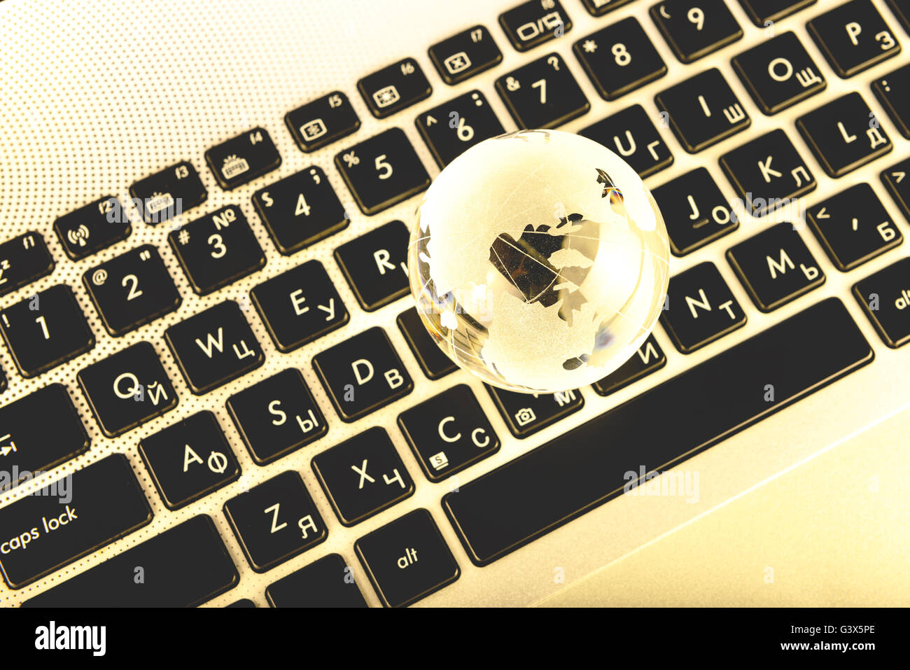 business concept of a glass globe on a laptop keyboard Stock Photo - Alamy