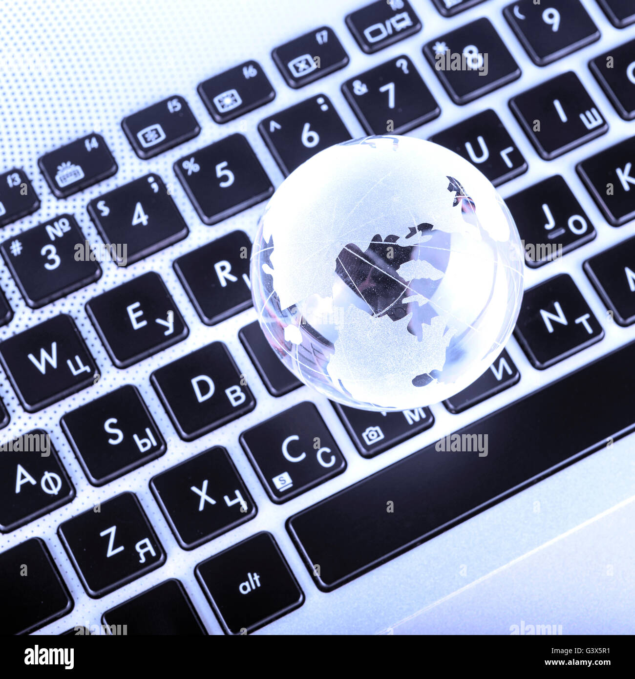 business concept of a glass globe on a laptop keyboard Stock Photo - Alamy