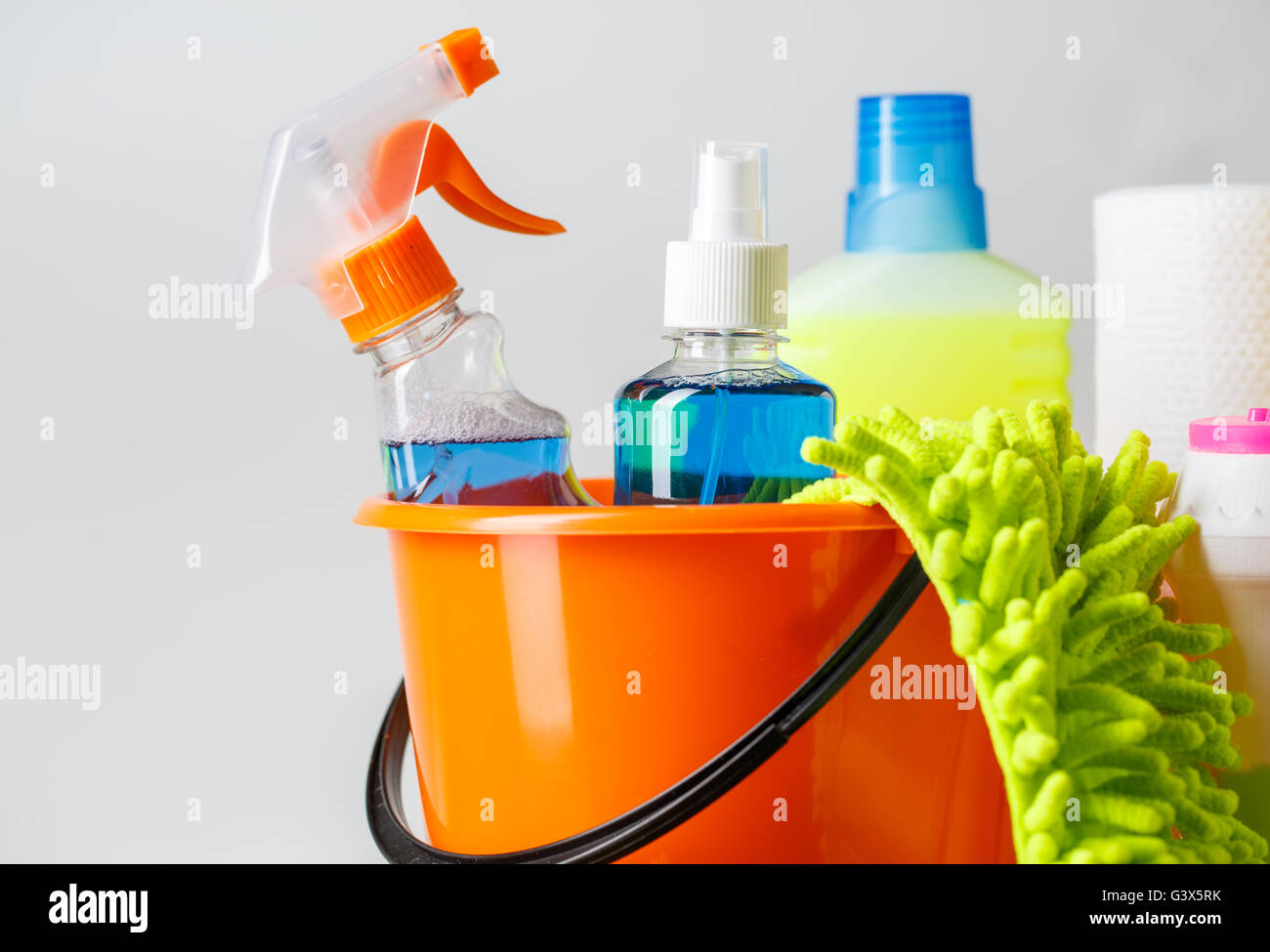 Bucket with cleaning items on light background Stock Photo - Alamy