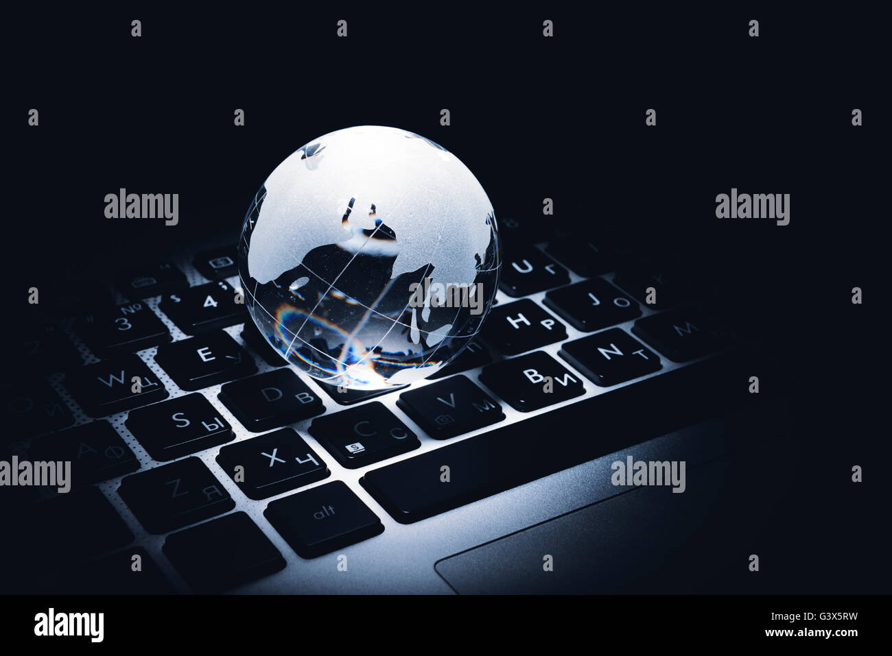 business concept of a glass globe on a laptop keyboard Stock Photo - Alamy