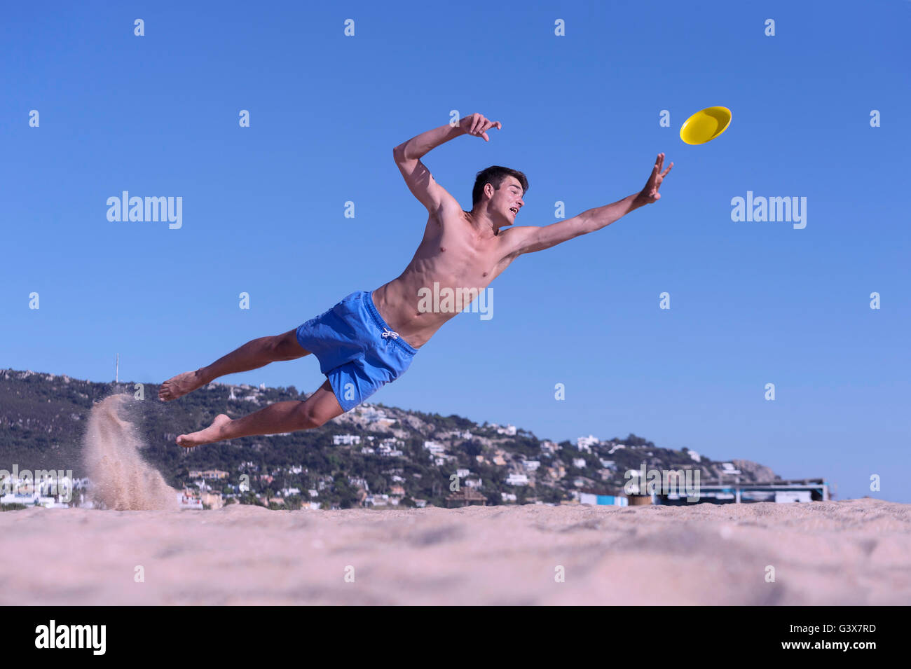 Boy Dives to Catch Frisbee. Boy is launched to capture the frisbee on ...