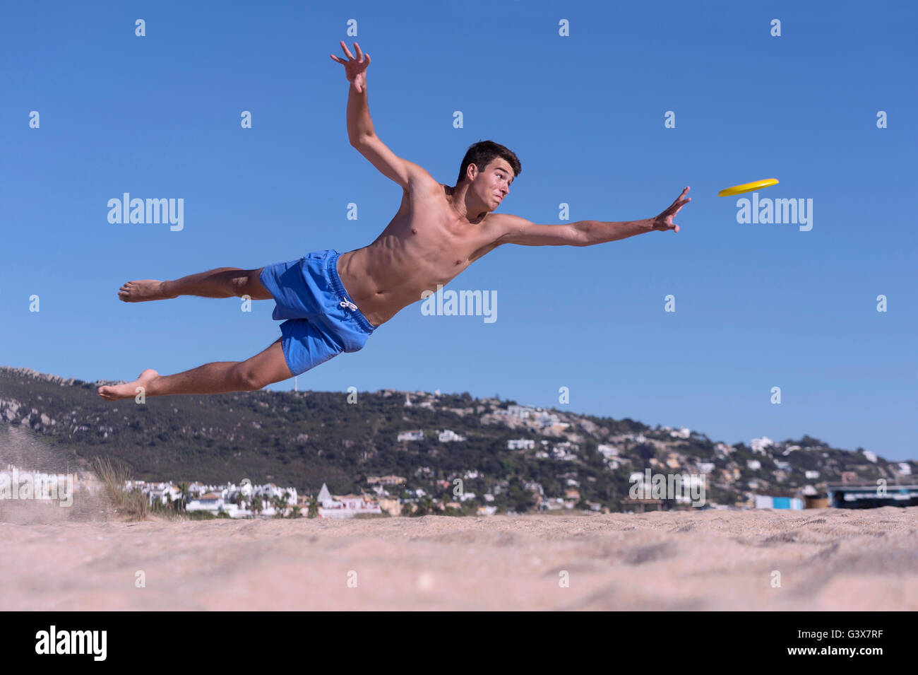 Boy Dives to Catch Frisbee. Boy is launched to capture the frisbee on ...
