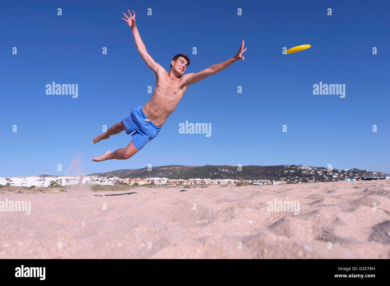 Boy Dives to Catch Frisbee. Boy is launched to capture the frisbee on ...
