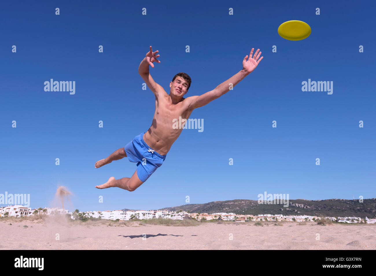 Boy Dives to Catch Frisbee. Boy is launched to capture the frisbee on ...