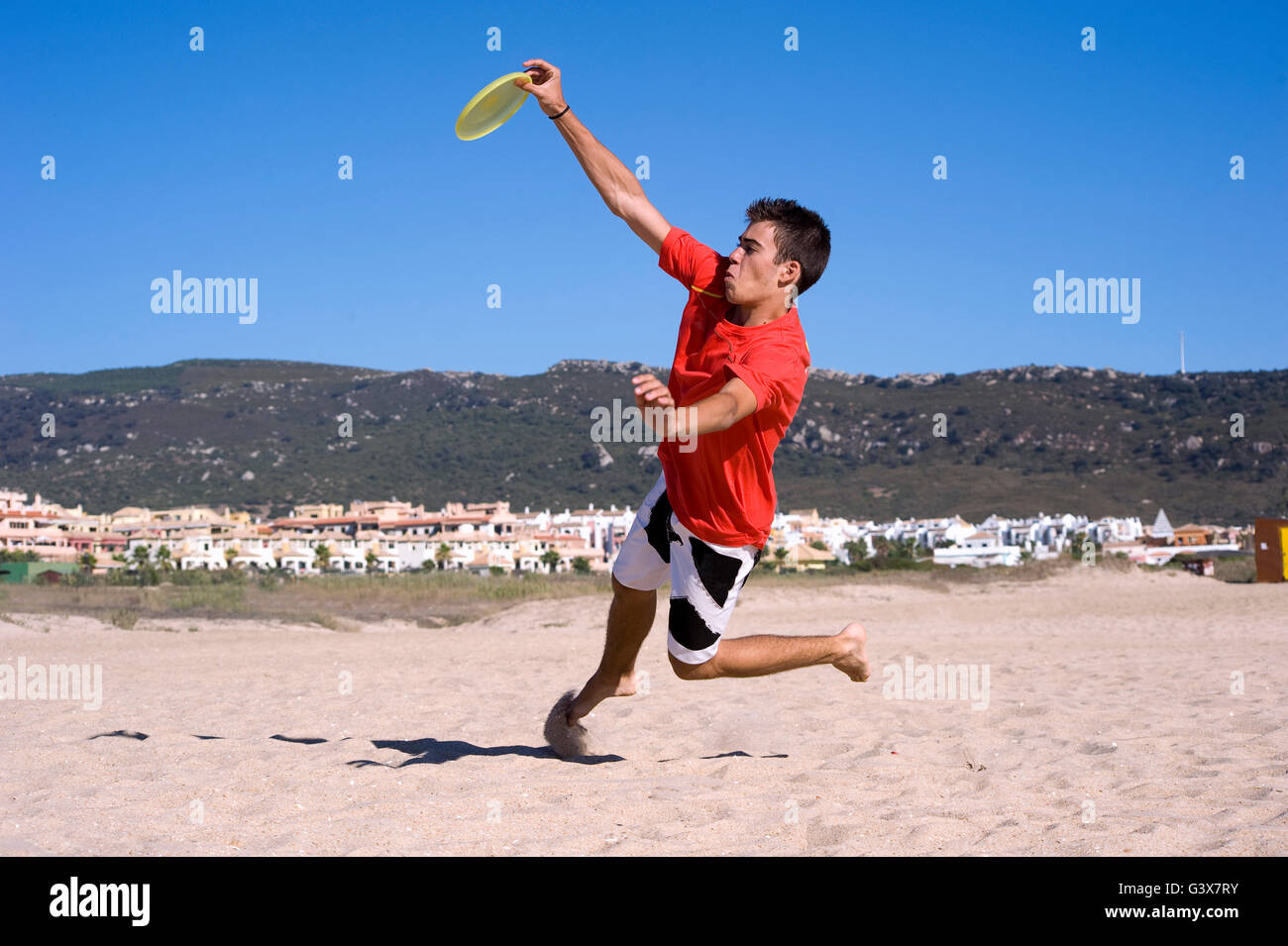 Boy Dives to Catch Frisbee. Boy is launched to capture the frisbee on ...