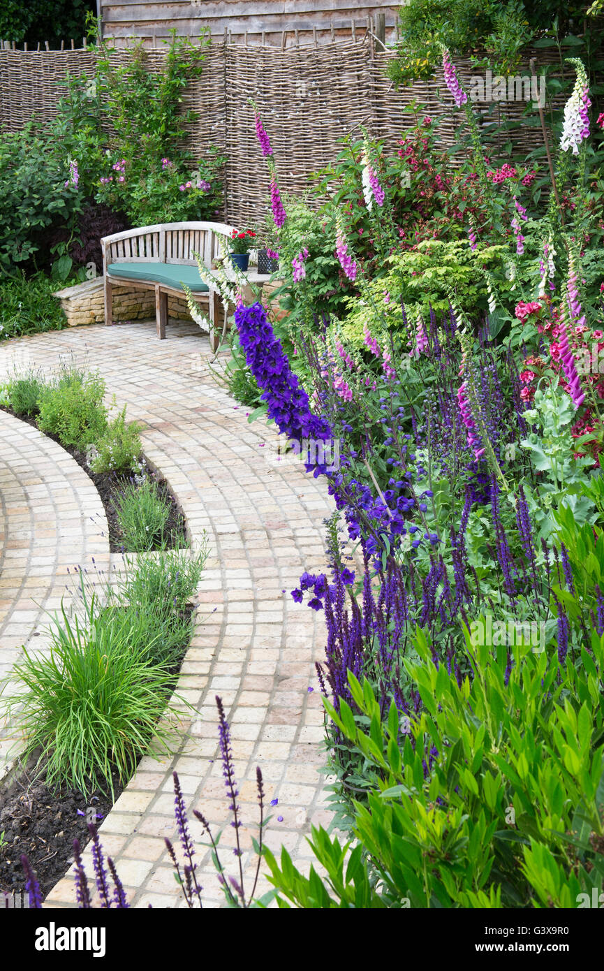 Curved flower border and block paving in an english cottage garden ...