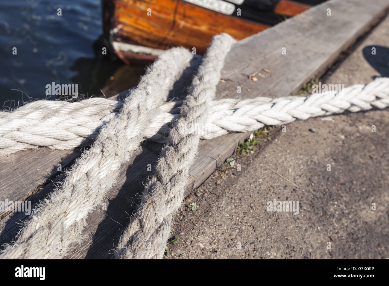 Nautical ropes used for mooring operations lay on the pier, closeup ...