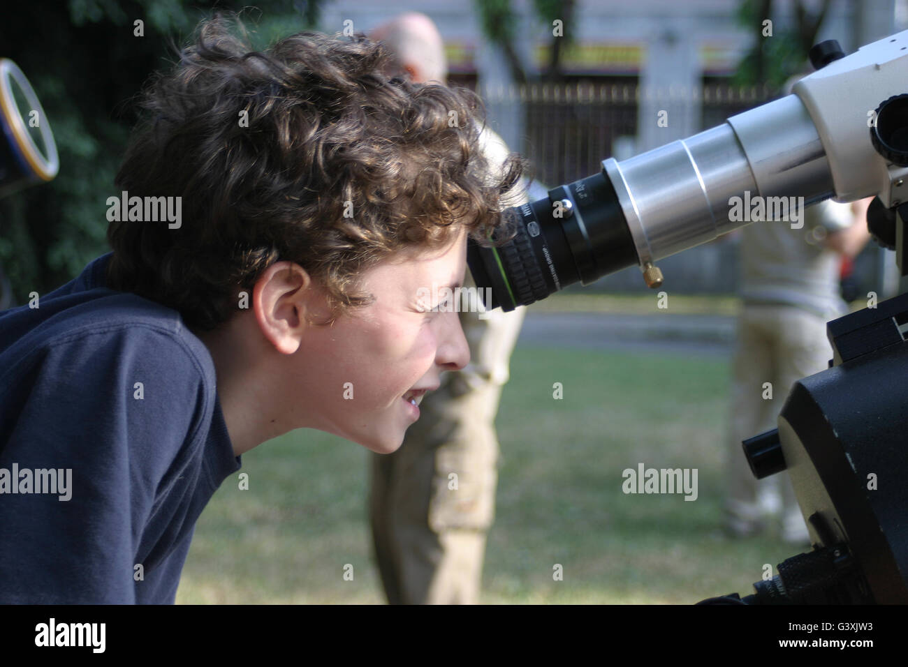 a young boy looking through a professional telescope Stock Photo - Alamy