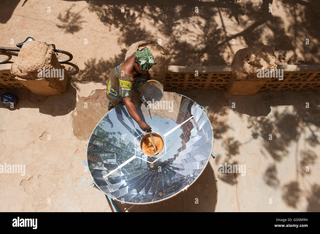 MALI Bandiagara, woman with solar cooker preparing food in village ...