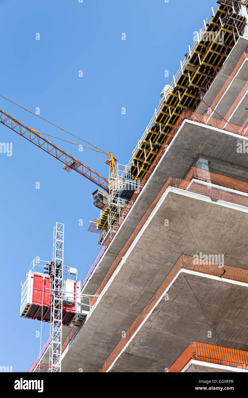 Multi-level concrete building under construction with tower crane Stock ...