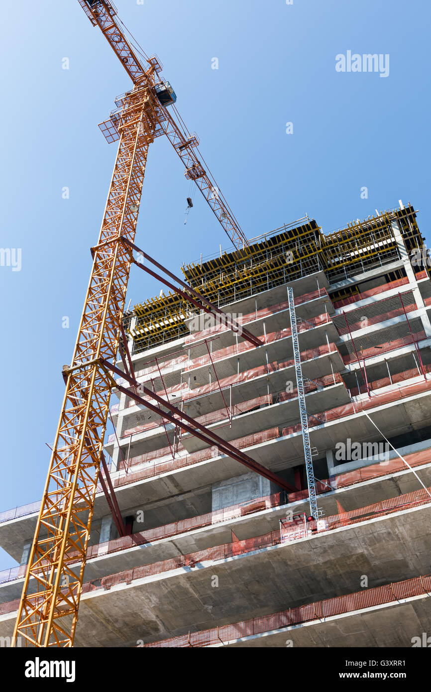 Concrete building under construction with tower crane Stock Photo - Alamy