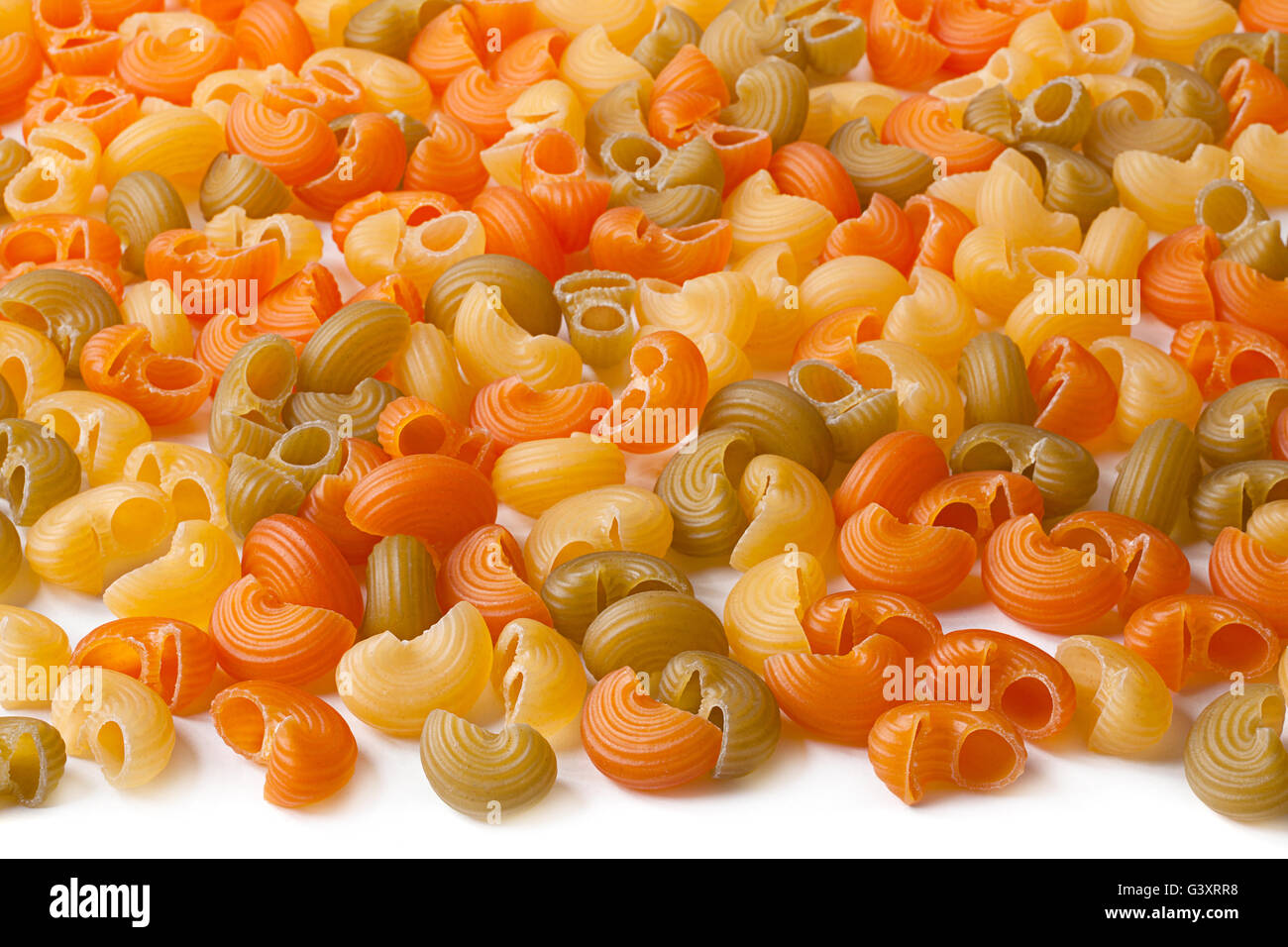Multicolor dry swirl pasta closeup background Stock Photo - Alamy