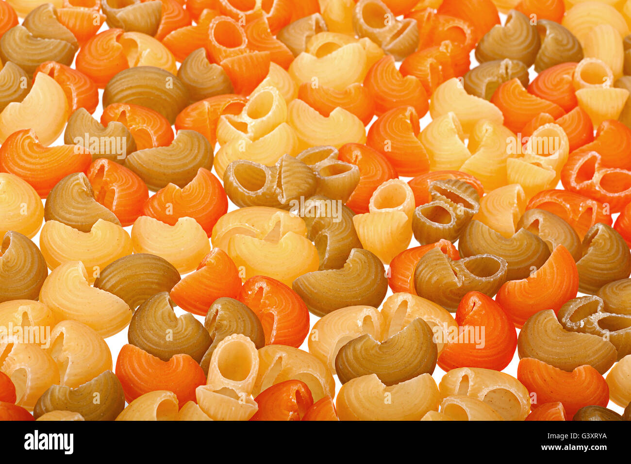 Multicolor dry swirl pasta closeup background Stock Photo - Alamy