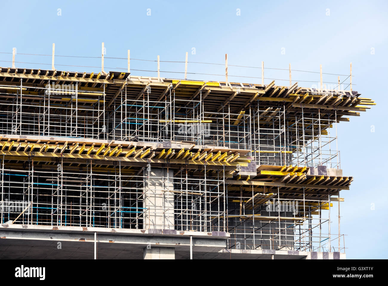 Incomplete concrete building under construction with scaffolding detail ...