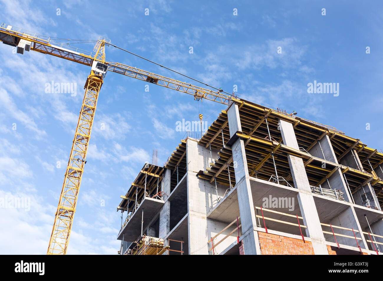 Residential high-rise construction and yellow tower crane over clear ...
