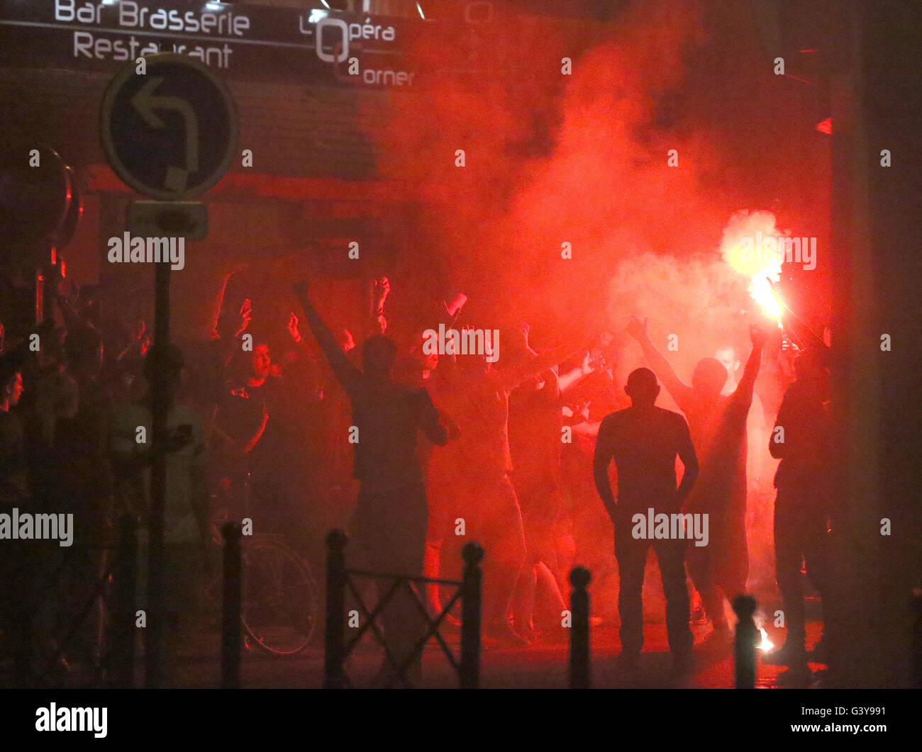 England fans lit by a burning flare in Lille city centre, France, as ...