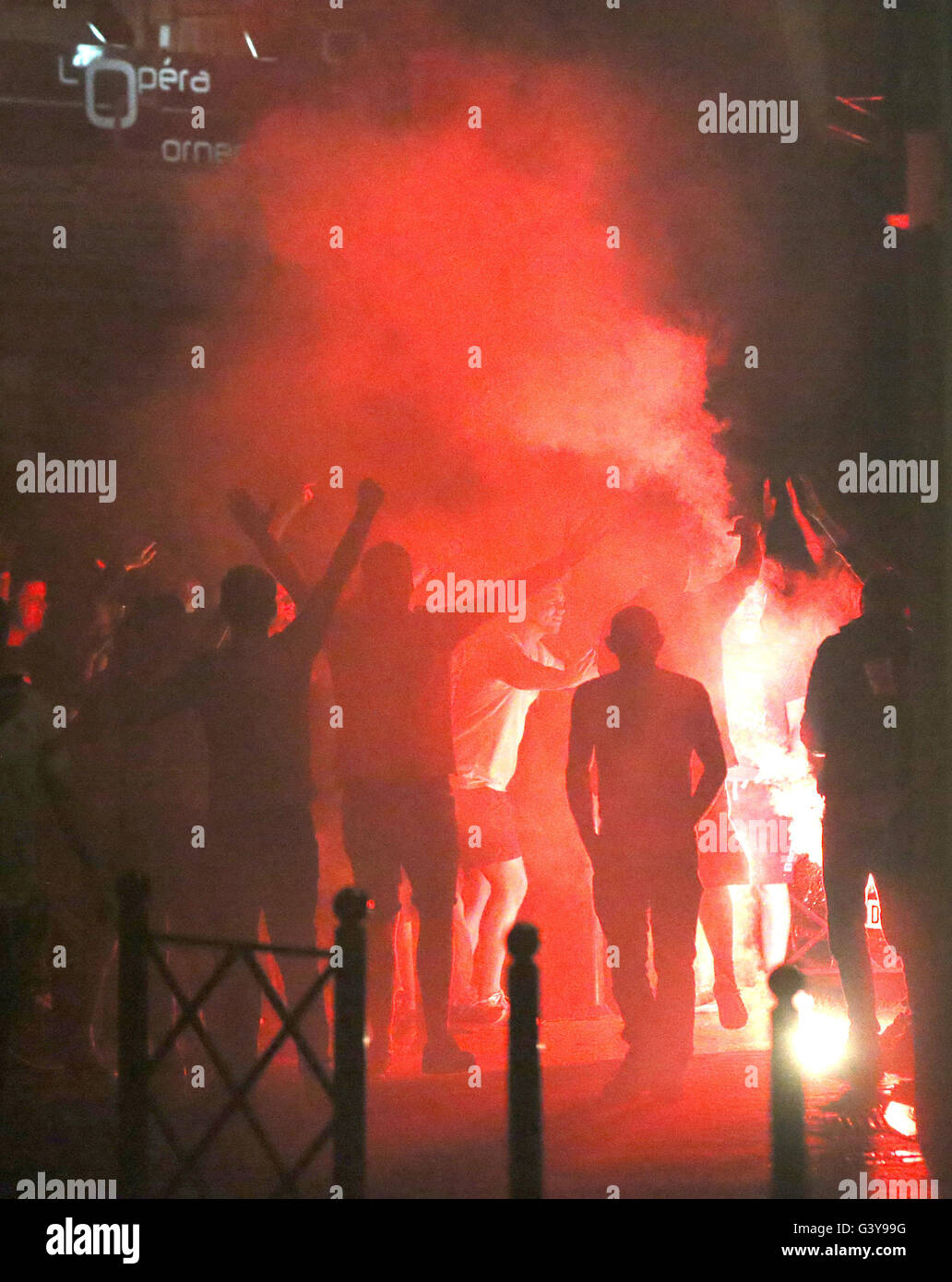 England fans lit by a burning flare in Lille city centre, France, as ...