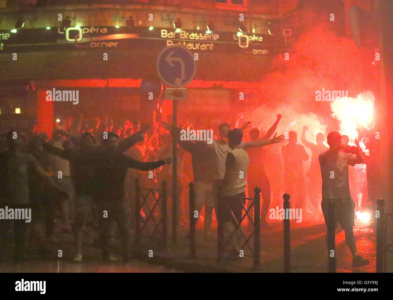 England fans lit by a burning flare in Lille city centre, France, as ...