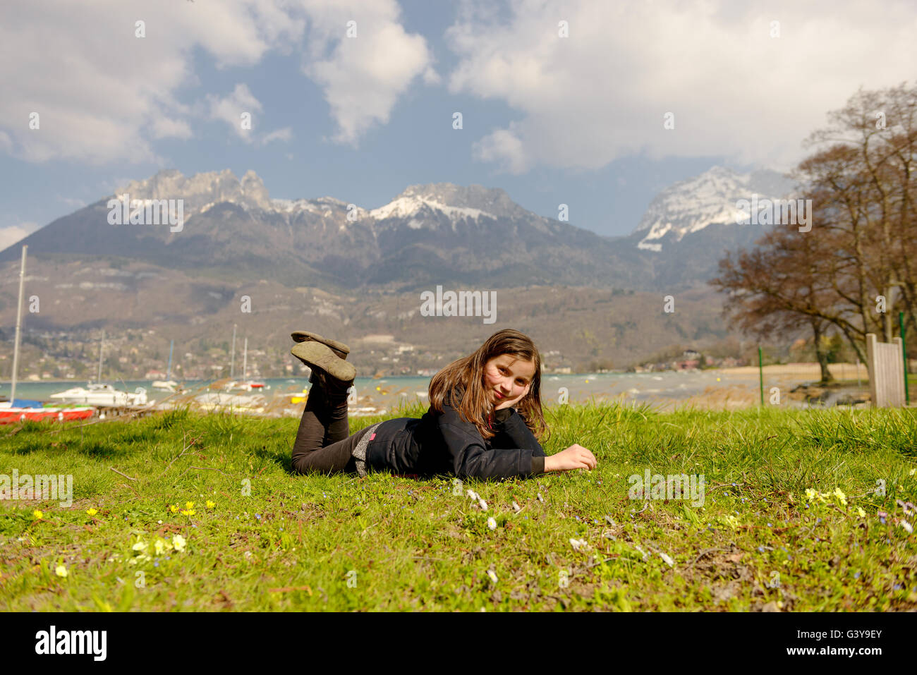 a pretty preteen is lying in the green grass, in the spring Stock Photo ...