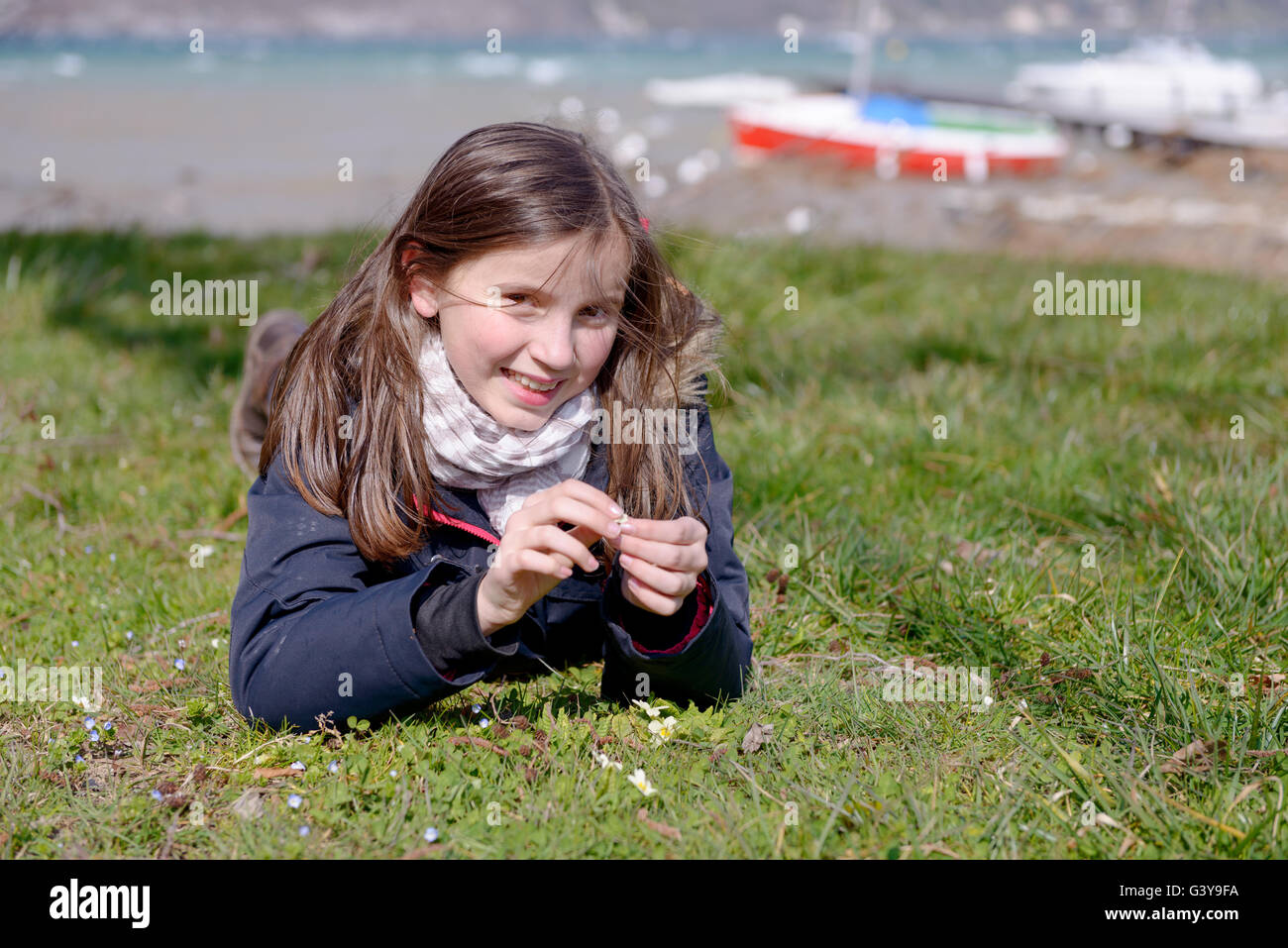 a pretty preteen is lying in the green grass, in the spring Stock Photo ...