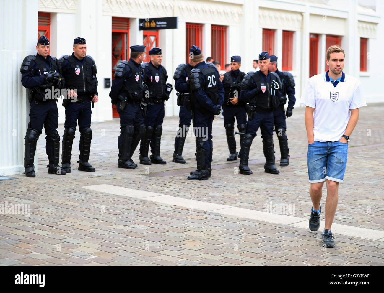 An England fan walks past police officers at Lens railway station ...