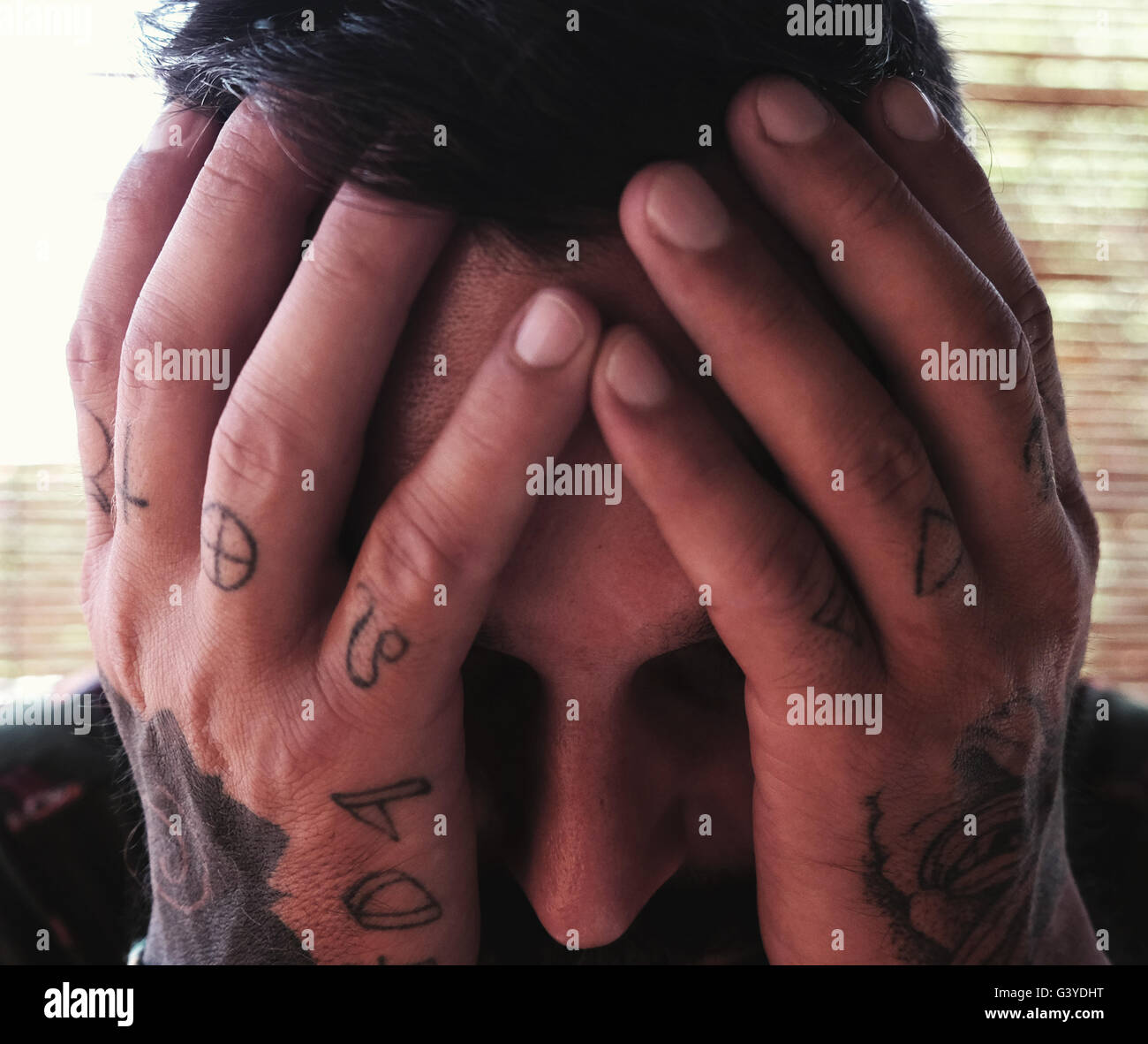 Man holding his head in his hands Stock Photo - Alamy